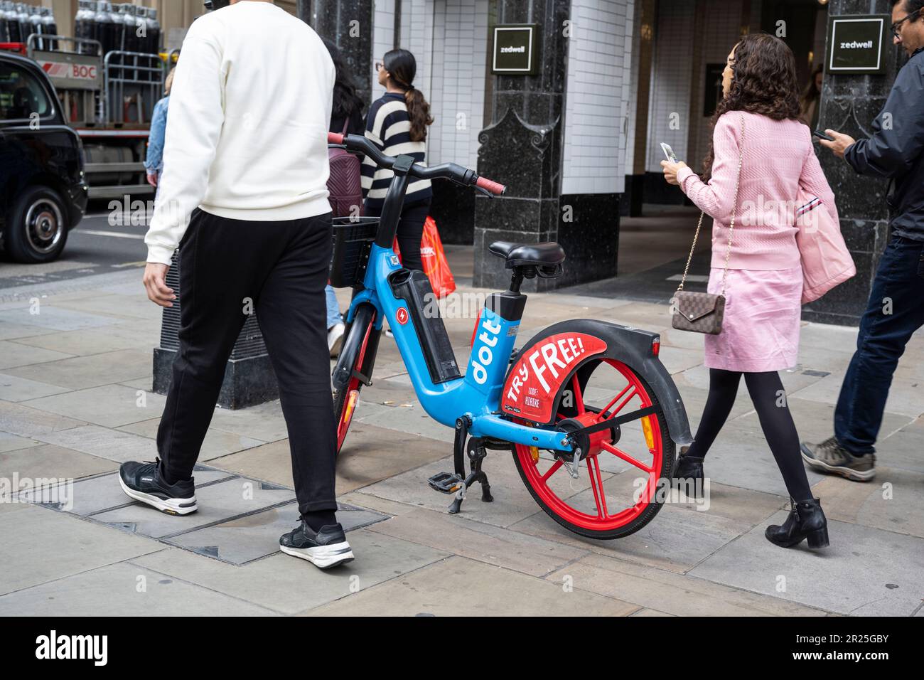 London, UK. 17 May 2023. The public passes an electric hire cycle on a ...