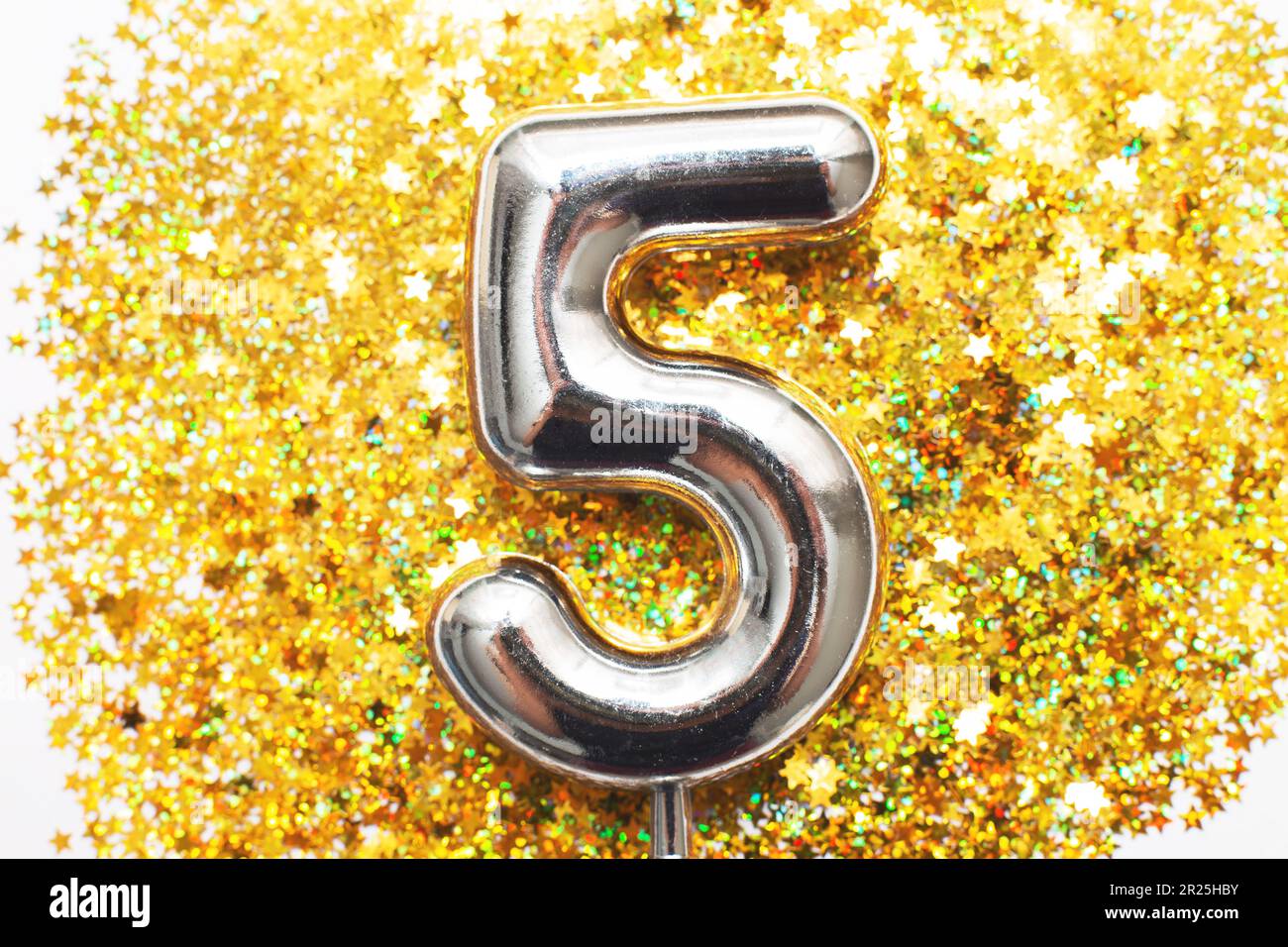 Five years birthday party. Festive silver big number five with golden ...