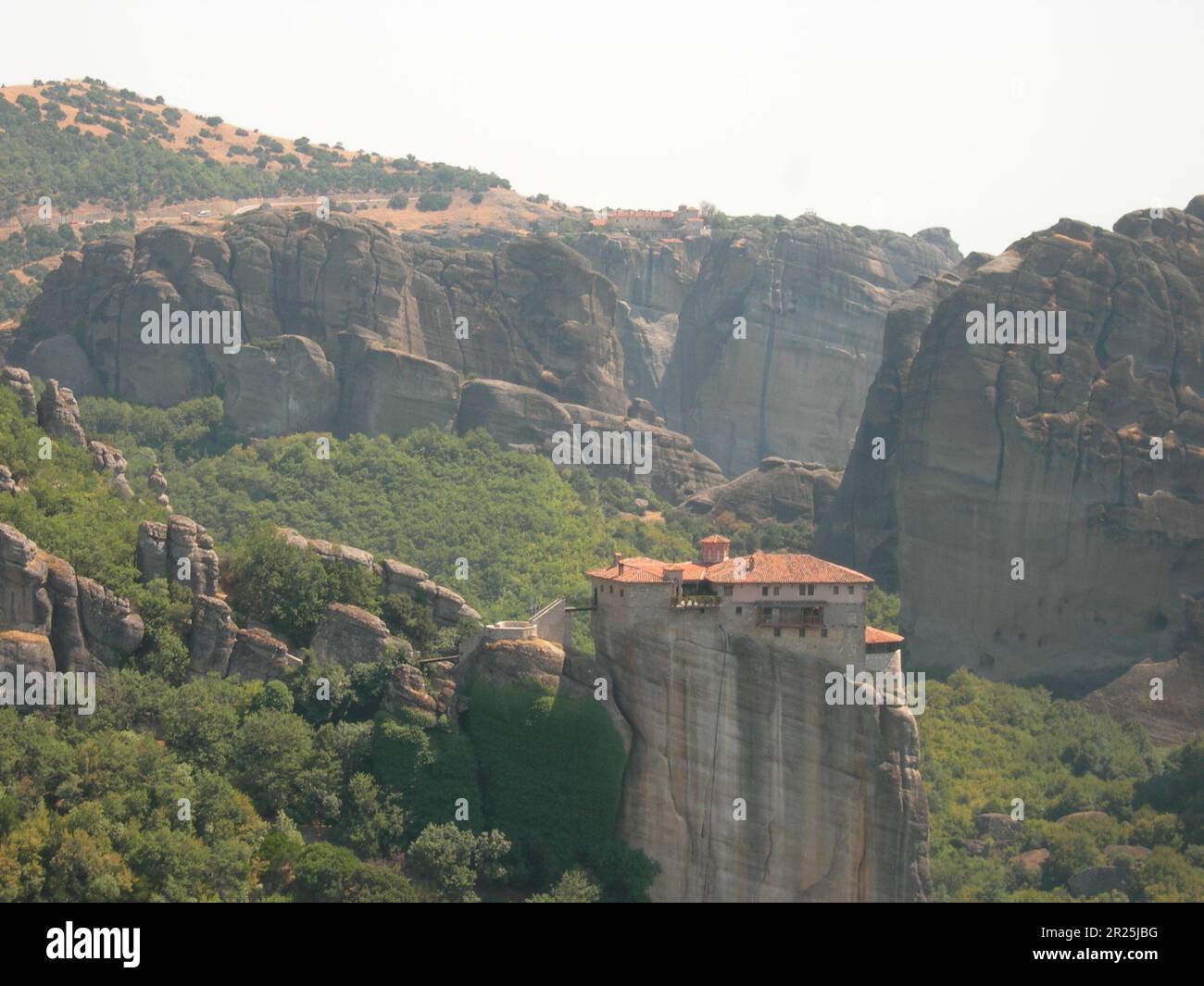 A large Monastery on top of a rock formation in Greece during the ...