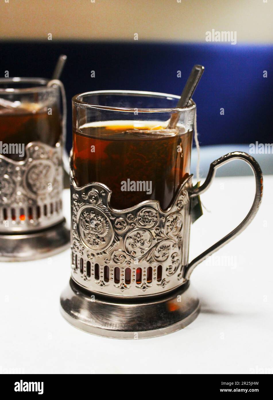 Glasses in metal holders with brewed tea bags on a table in a train ...