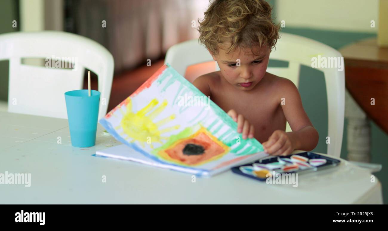 Toddler child boy creating and crafting aquarelle paint homework ...