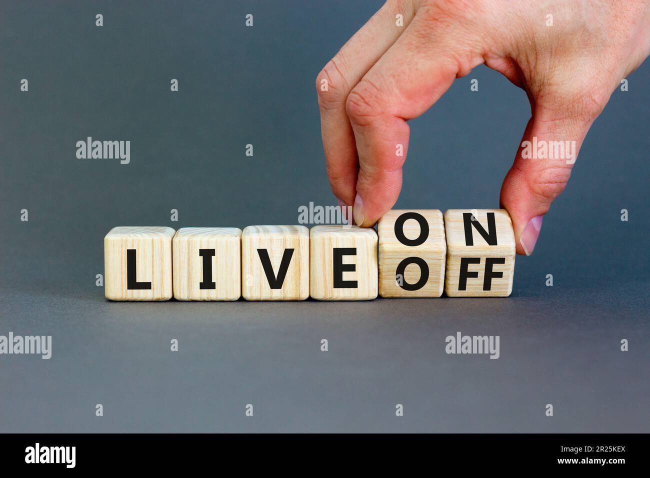Live on or off symbol. Businessman turns wooden cubes and changes word ...