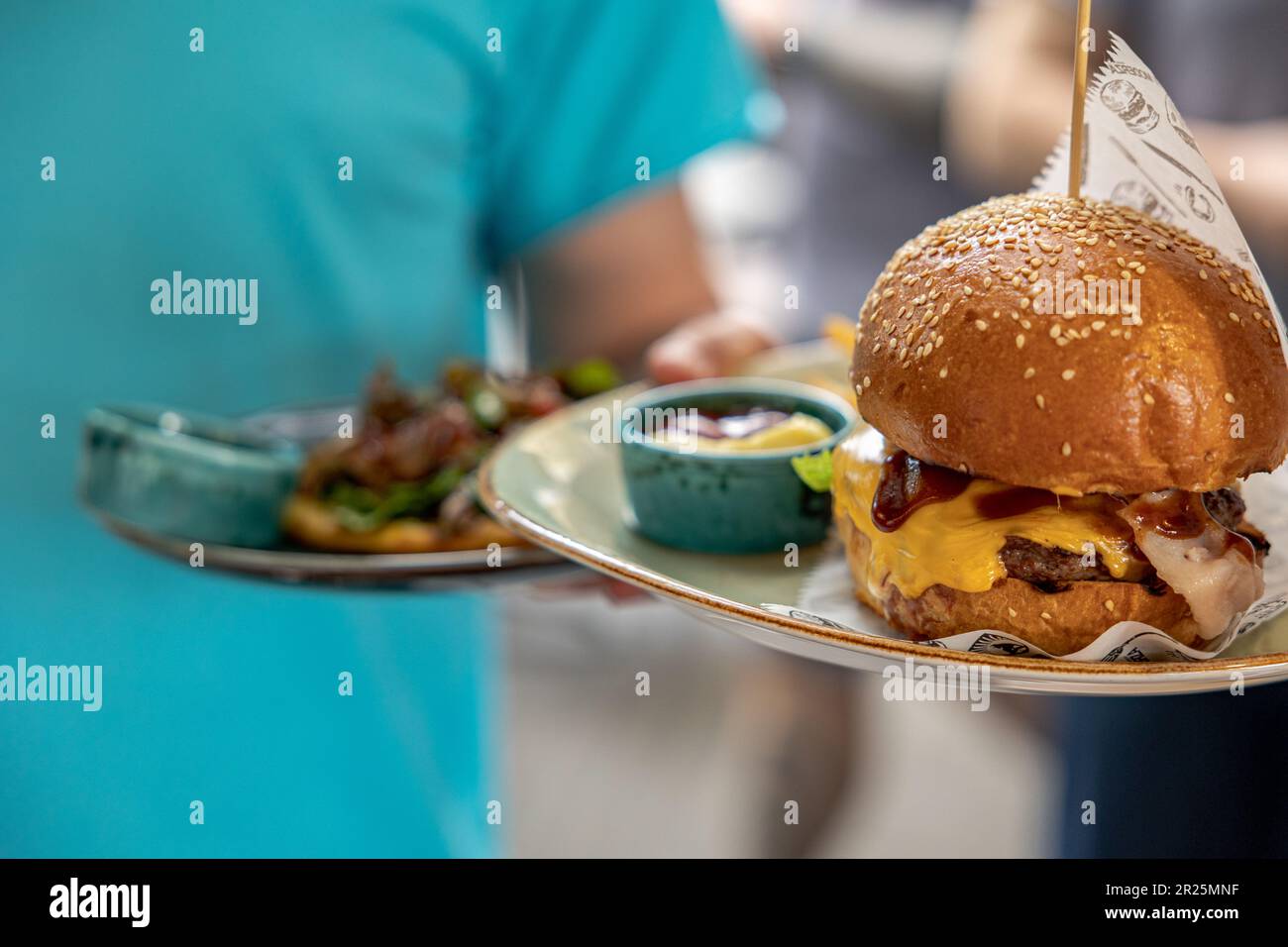 Waiter serving a delicious burger and sauce in the restaurant Stock ...