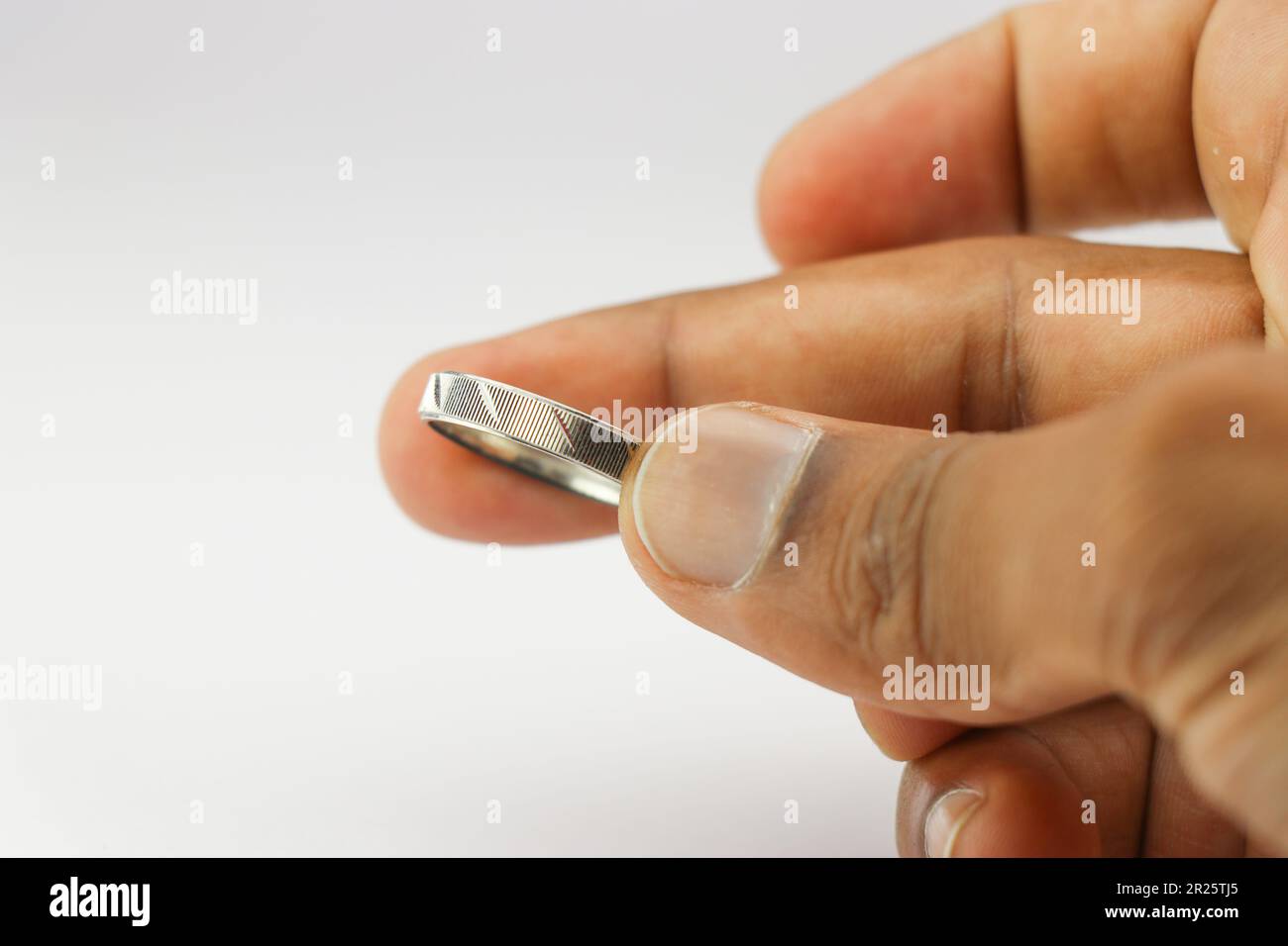 Silver ring with beautiful patterns held in the hand on a white ...
