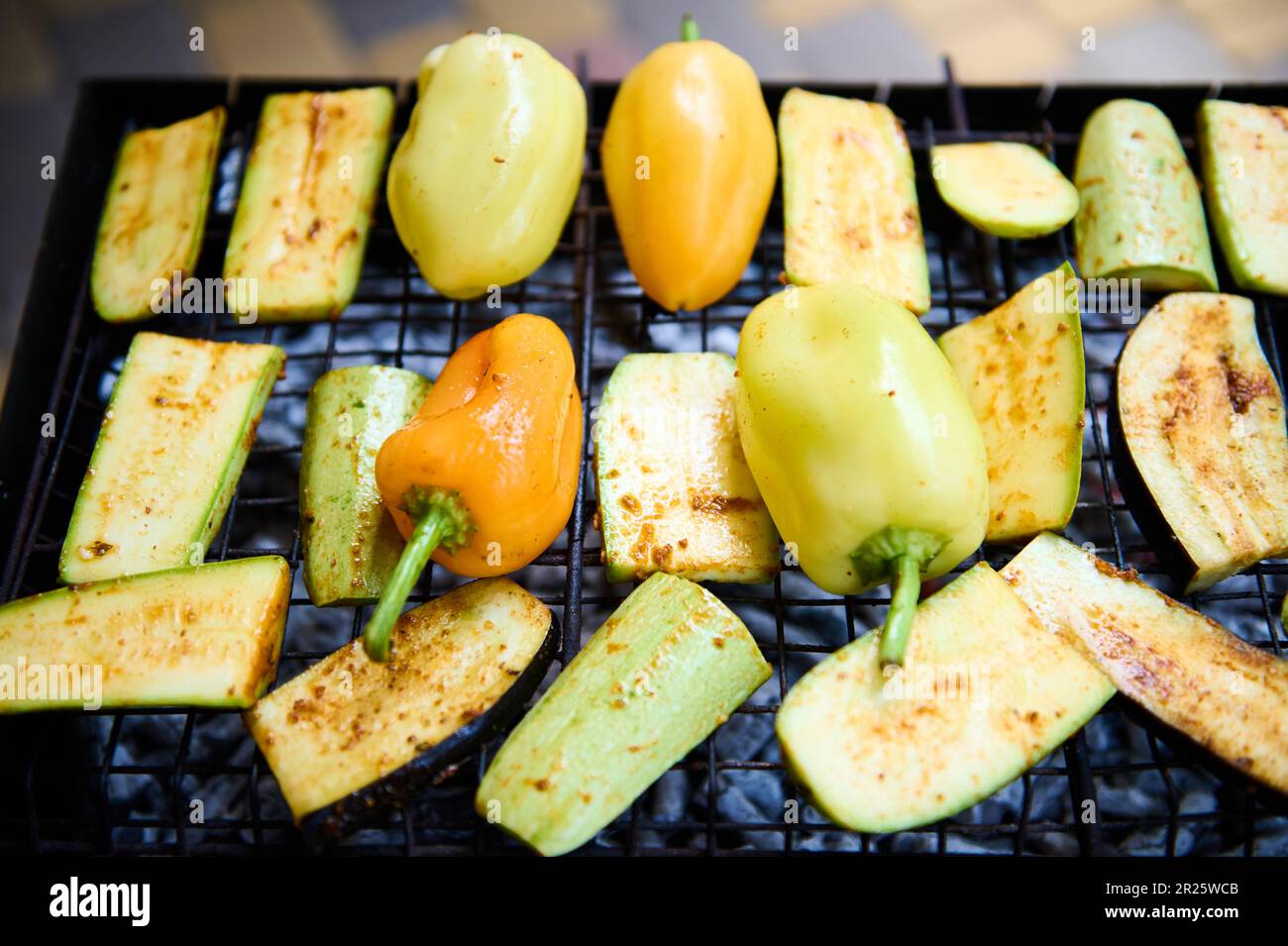 Top view seasoned bell peppers and zucchini slices grilling on the ...