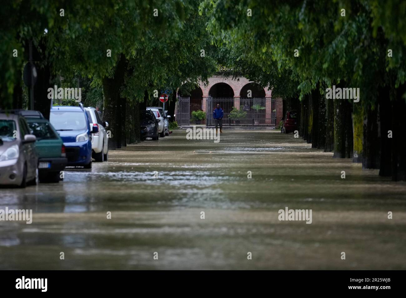 A man walks in the flooded village of Castel Bolognese, Italy ...
