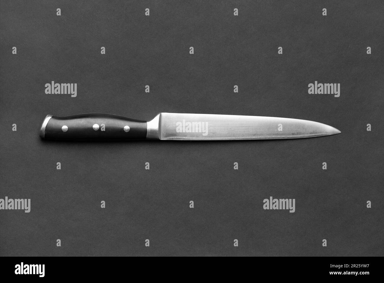 Kitchen knife with a black handle on a black background, copy space ...
