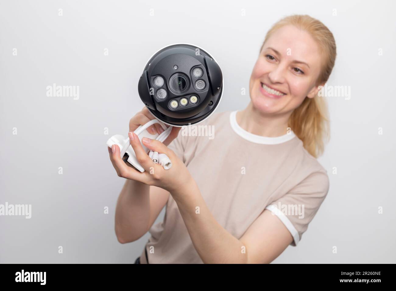 Smiling Caucasian Woman Holds IP Smart Outdoor Security Camera On White ...