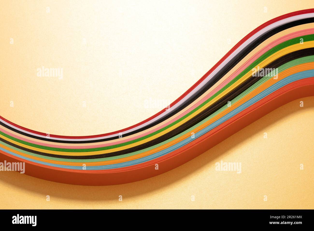 Beautiful curve of strip cut of multi-colored paper on golden textured ...