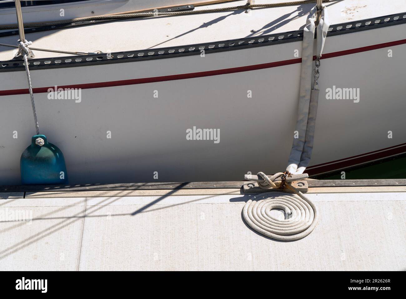 A boat with fender and mooring bollard with a fixed rope on the pier ...