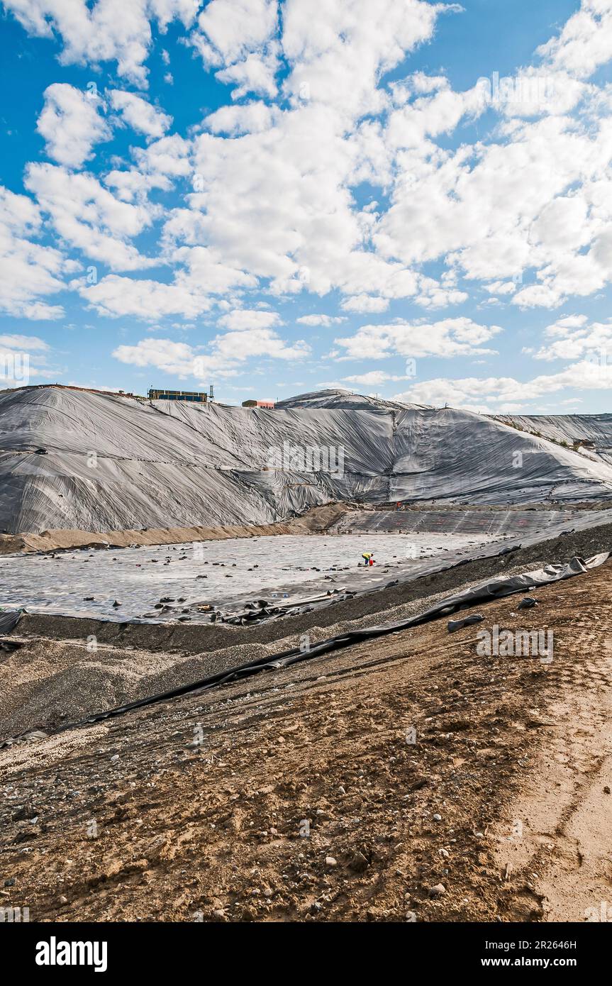 Two workers on geomembranes at an active landfill Stock Photo - Alamy