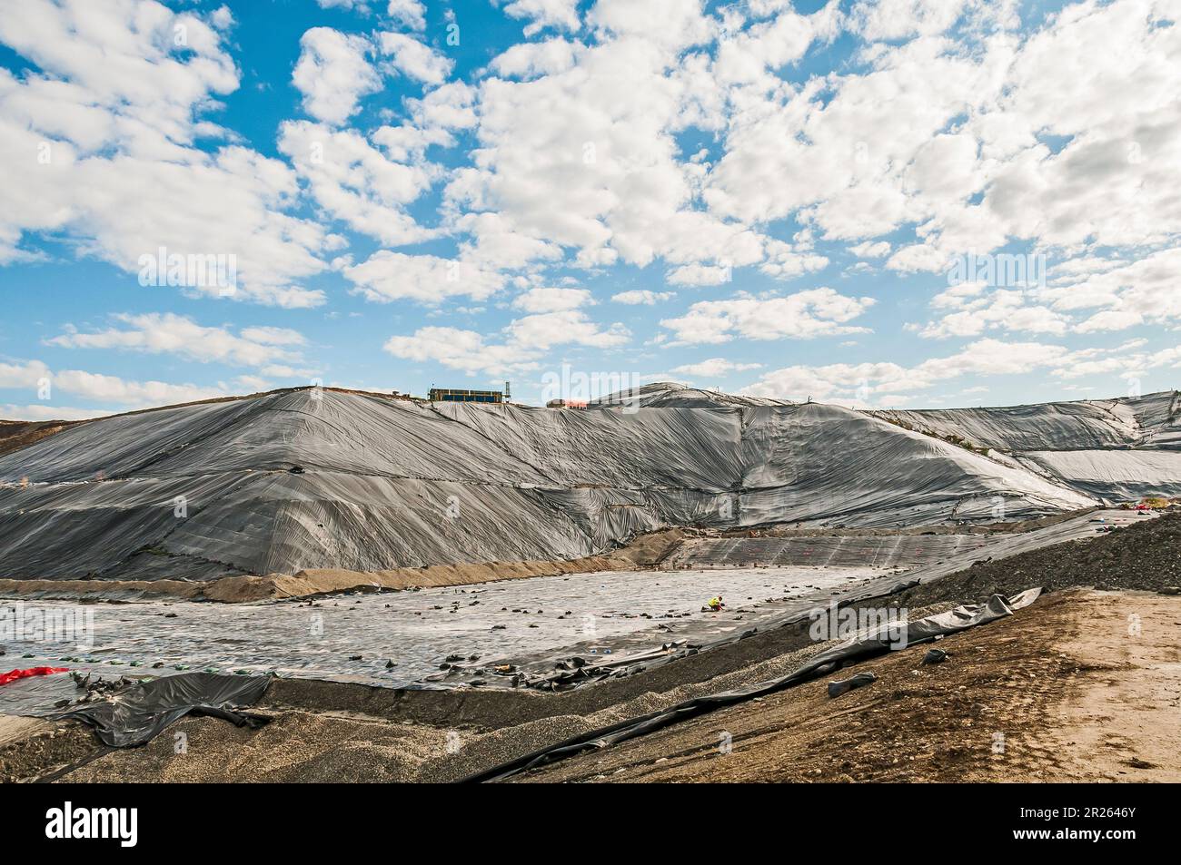 Two workers on geomembranes at an active landfill Stock Photo - Alamy