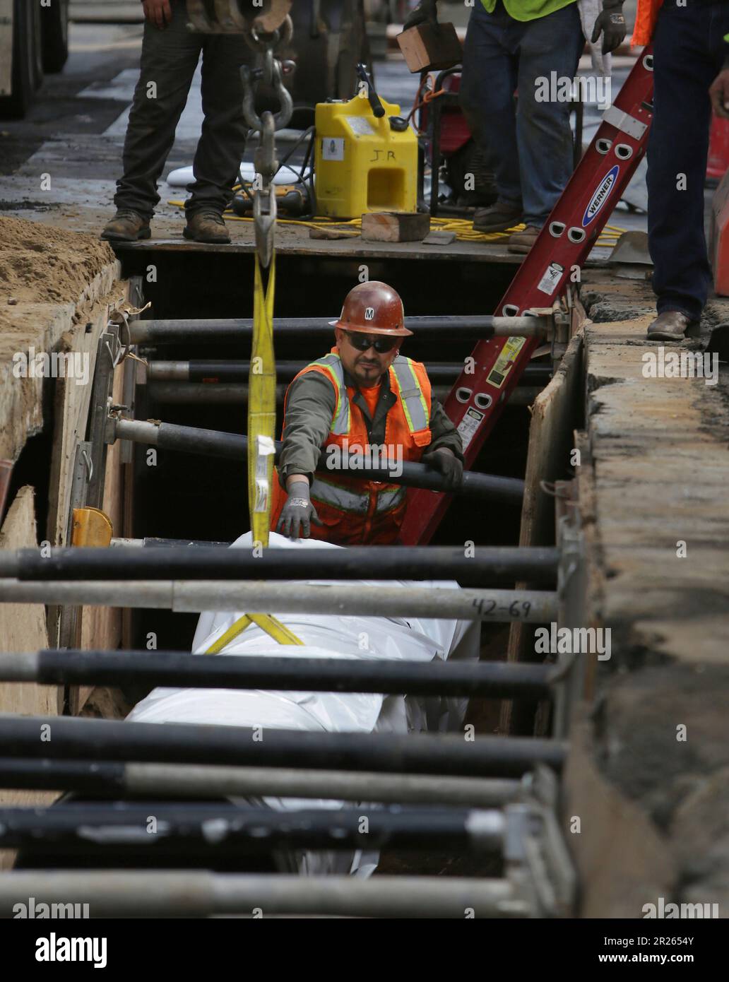 Martin Santos, Synergy laborer, and other workers guide a replacement ...