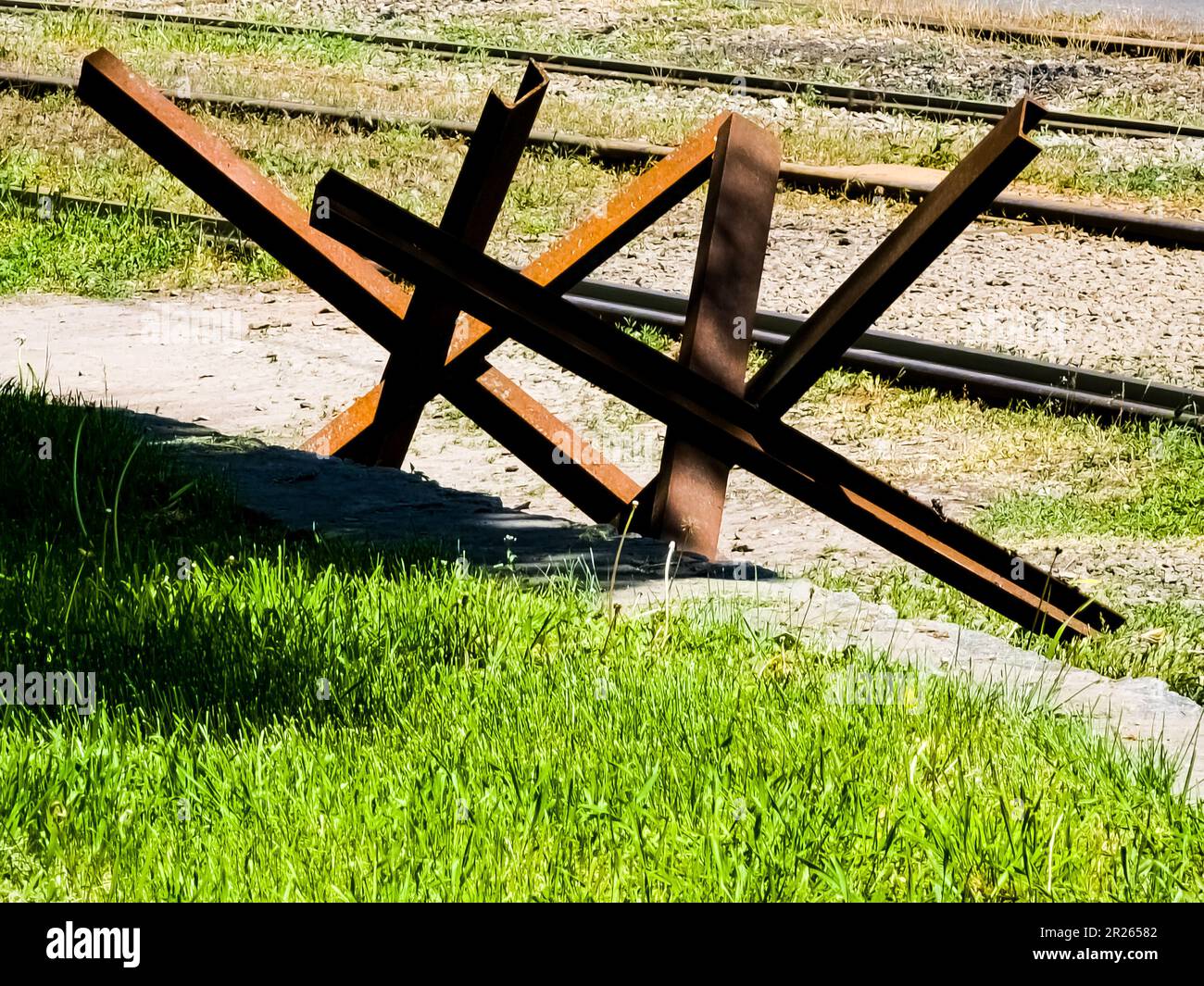 Rusty anti-tank hedgehogs on the grass in the frontline zone. War in ...