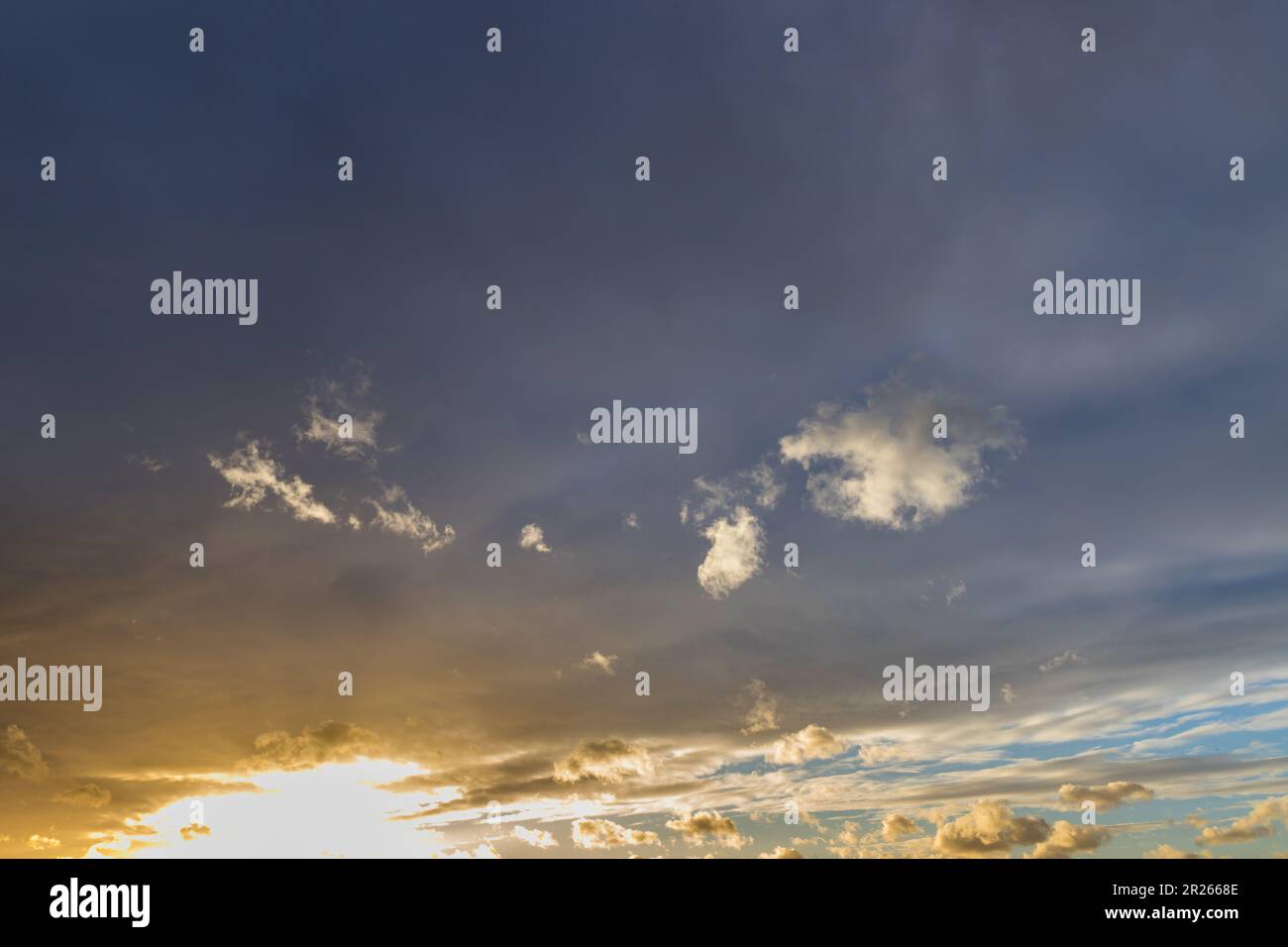 dark medium-high stratus clouds under which the sun shines through ...
