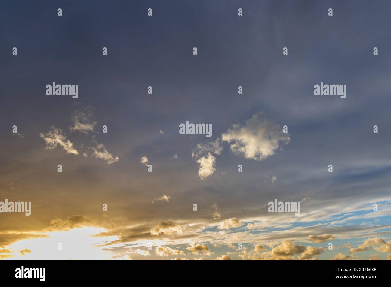 dark medium-high stratus clouds under which the sun shines through ...
