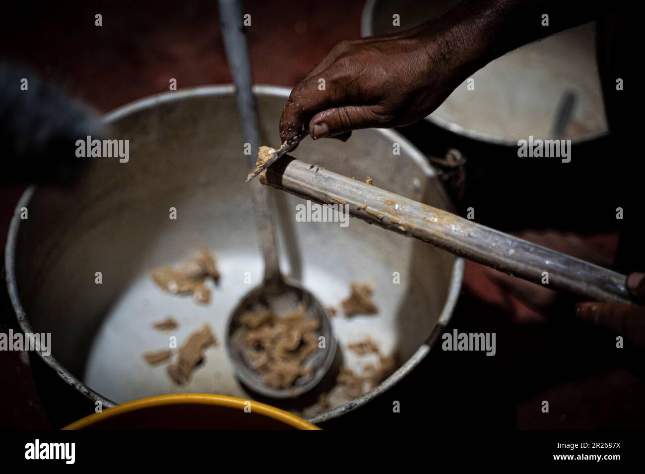 Llorente, Colombia. 11th May, 2023. A worker scrapes off a metal rod ...