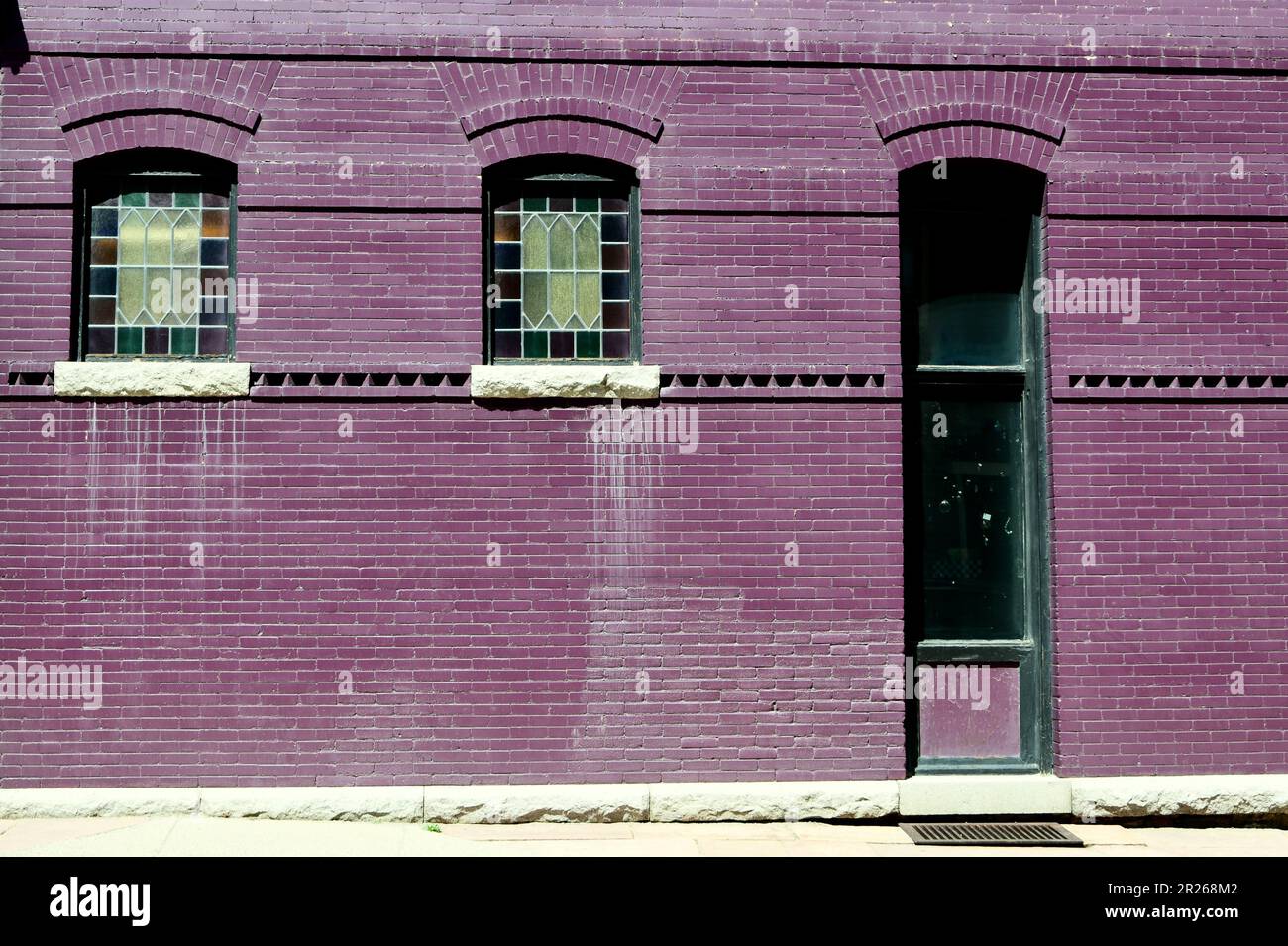 Purple and Black brick building storefront. Stained glass windows and ...