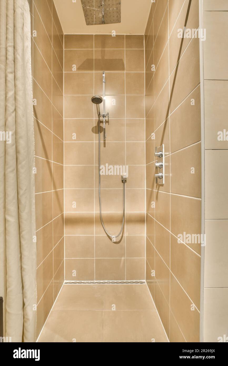a walk in shower with beige tiled walls and white tiles on the wall ...