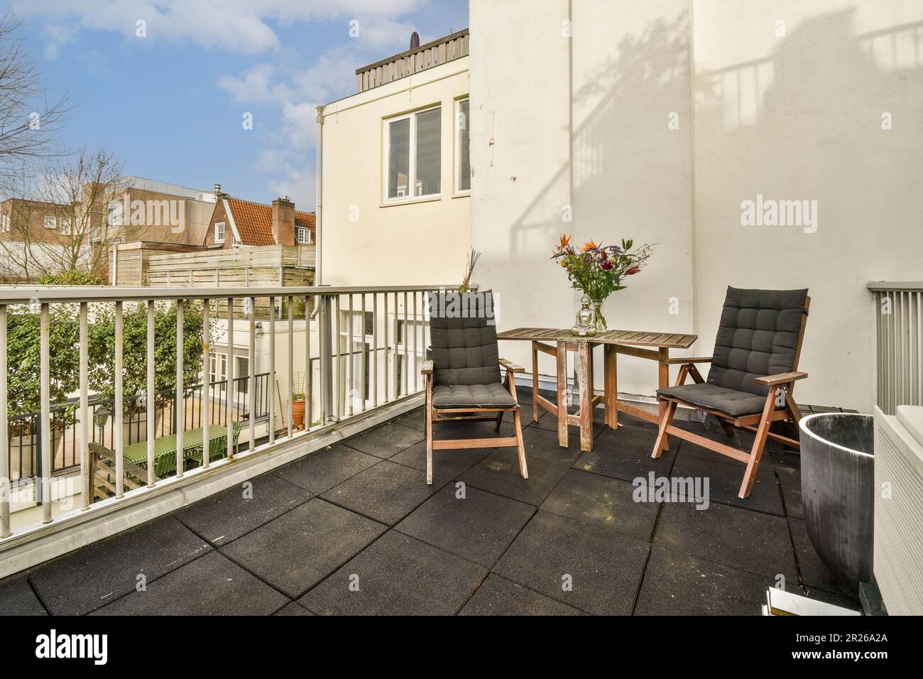 a balcony with two chairs and a table on the outside deck looking out ...