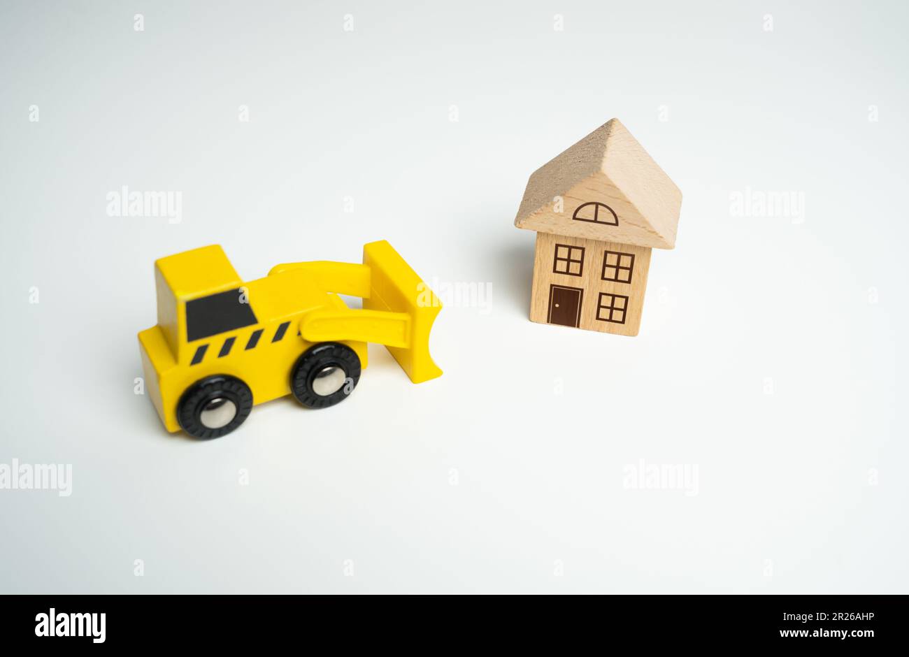 Yellow toy bulldozer and a house. Encroachment on private property ...