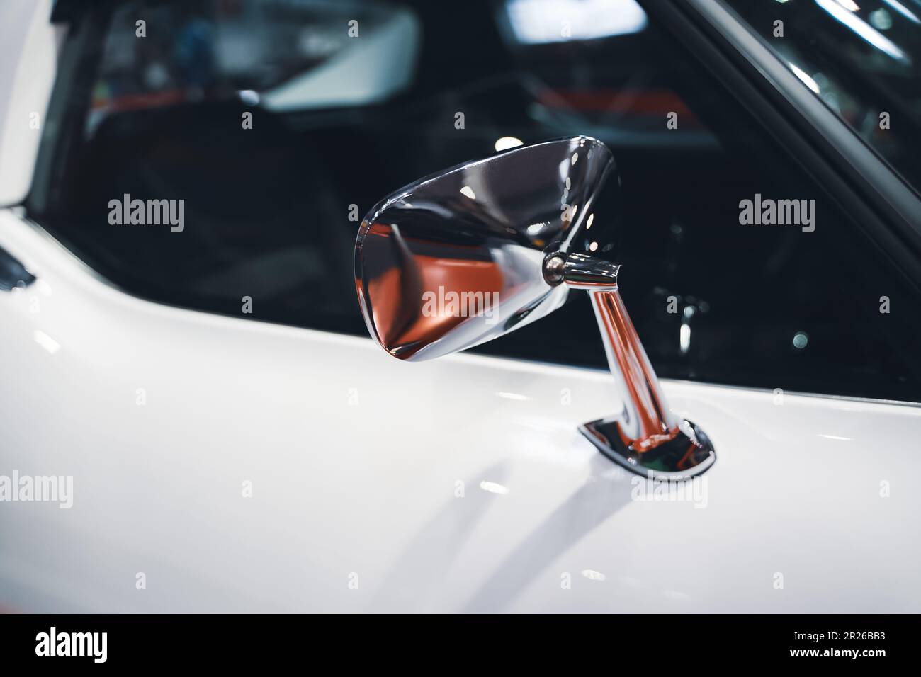 side view detail closeup of chrome rear mirror on white car with ...
