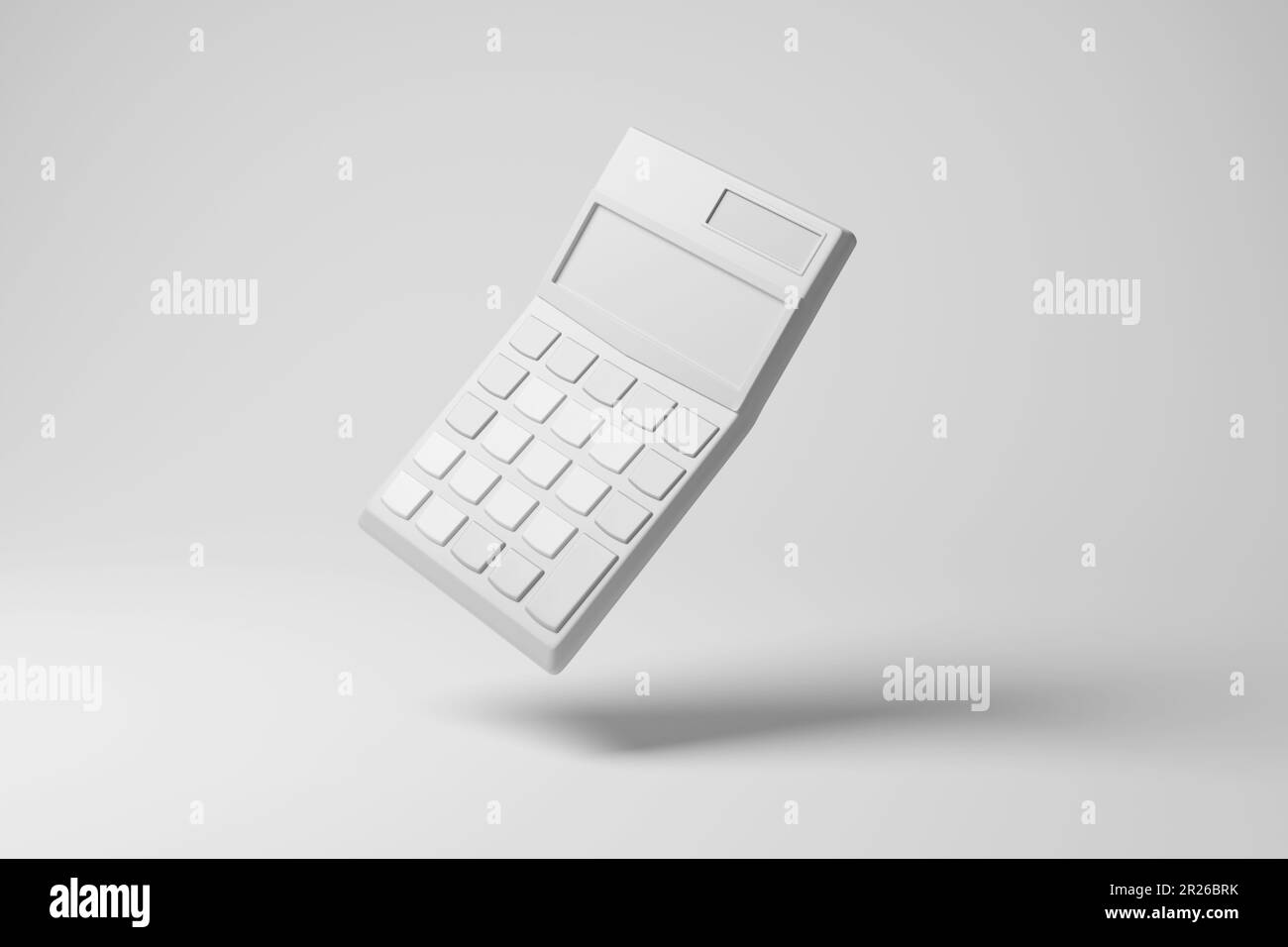 White calculator floating in mid air with shadow on white background creating monochrome ...