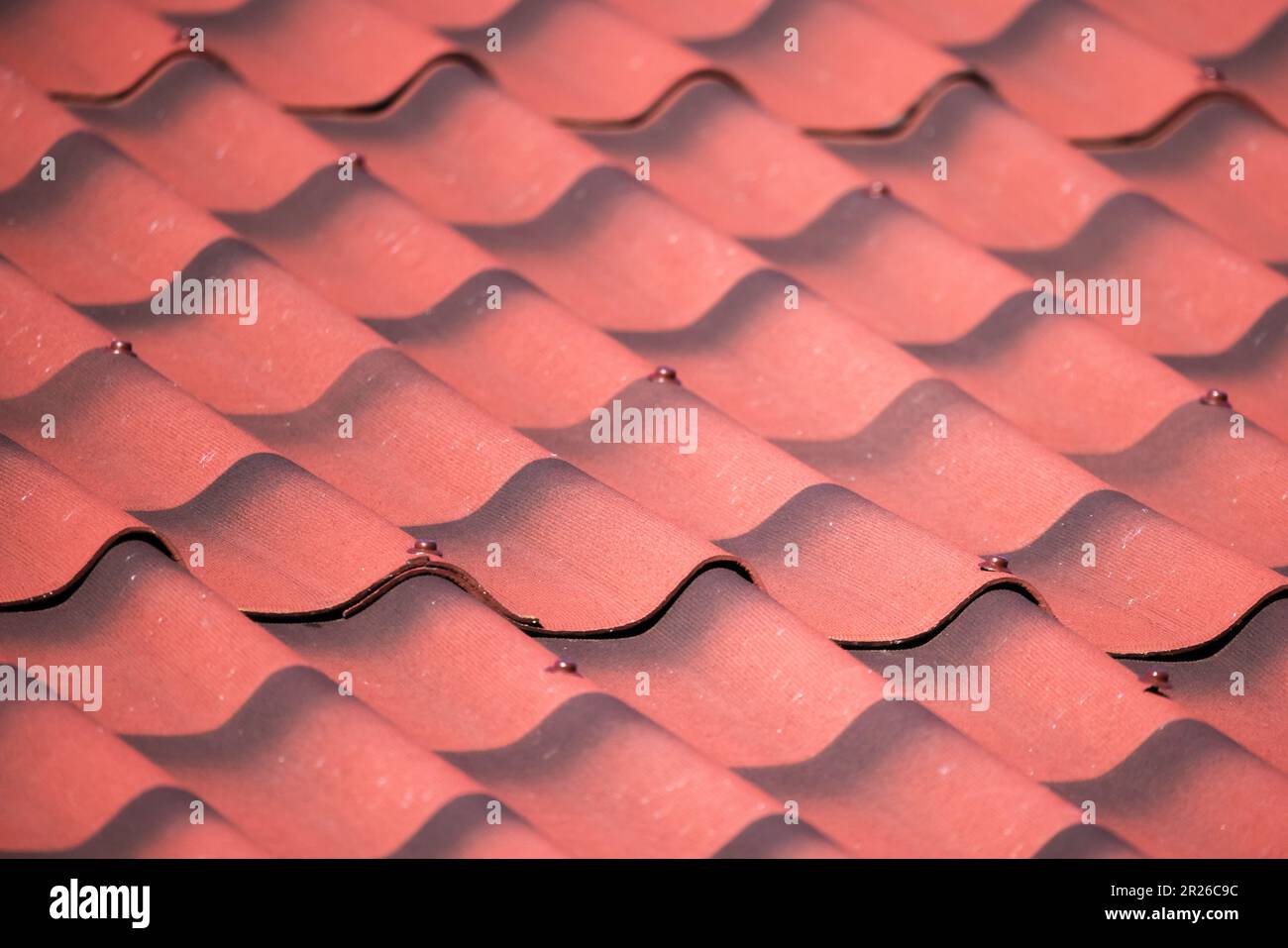 Imitation of red roof tiling from corrugated sheets of slate, close up ...