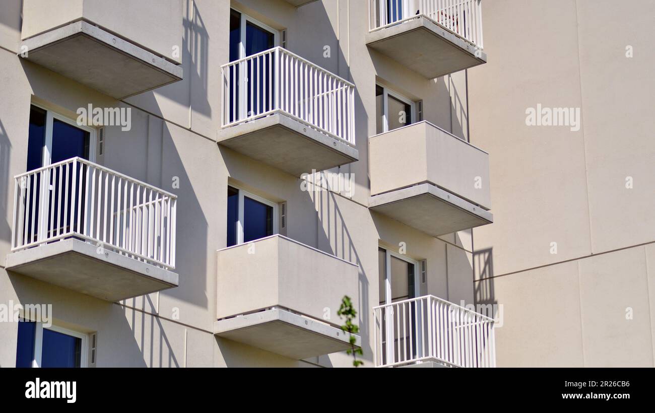 Apartment building with bright facades. Modern minimalist architecture with lots of square glass ...
