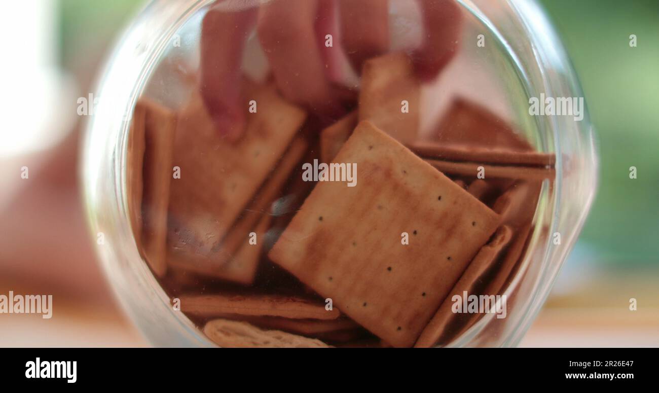 Closeup of child hands taking salt crackers from inside glass jar Stock ...