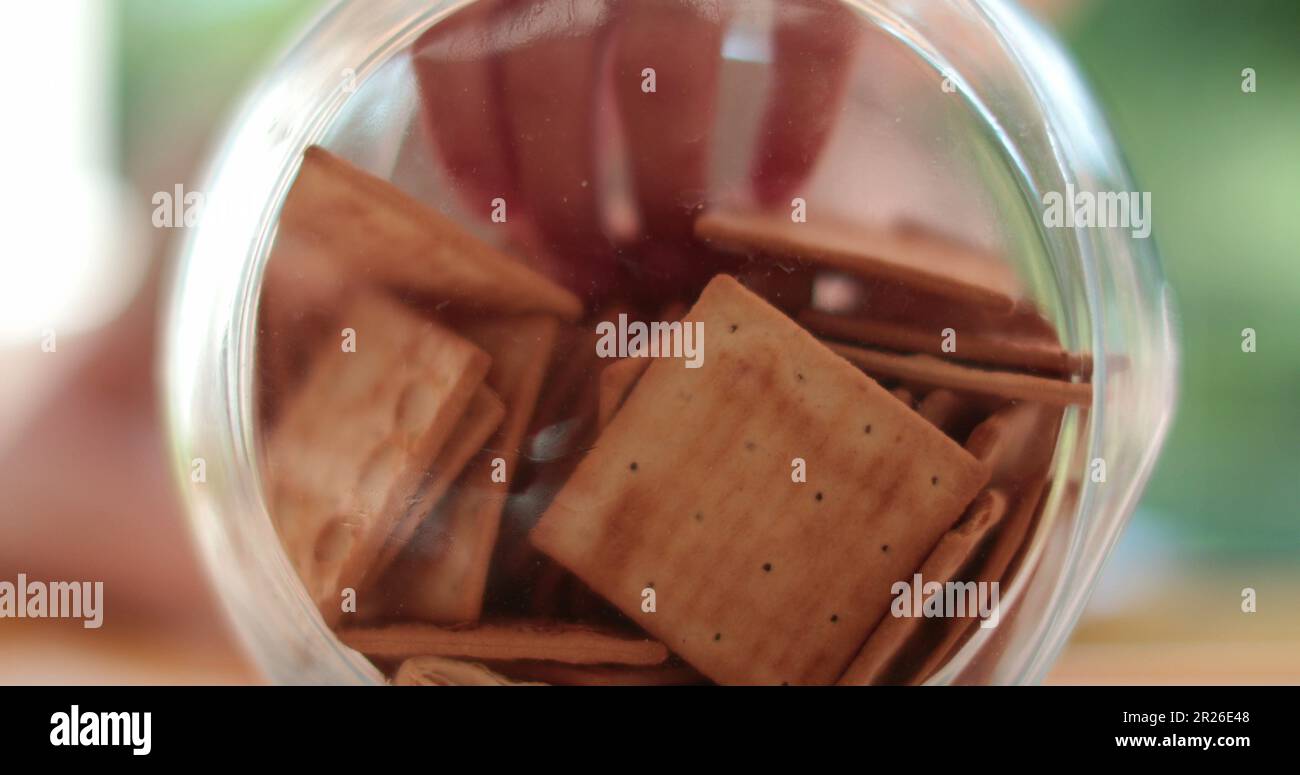 Closeup of child hands taking salt crackers from inside glass jar Stock ...