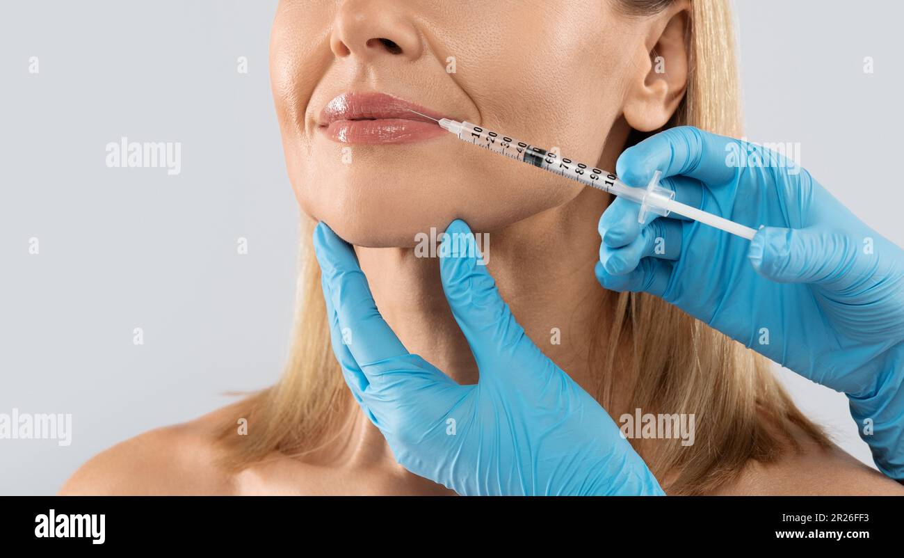 Adult woman gets cosmetic injection in her lips, cropped Stock Photo ...
