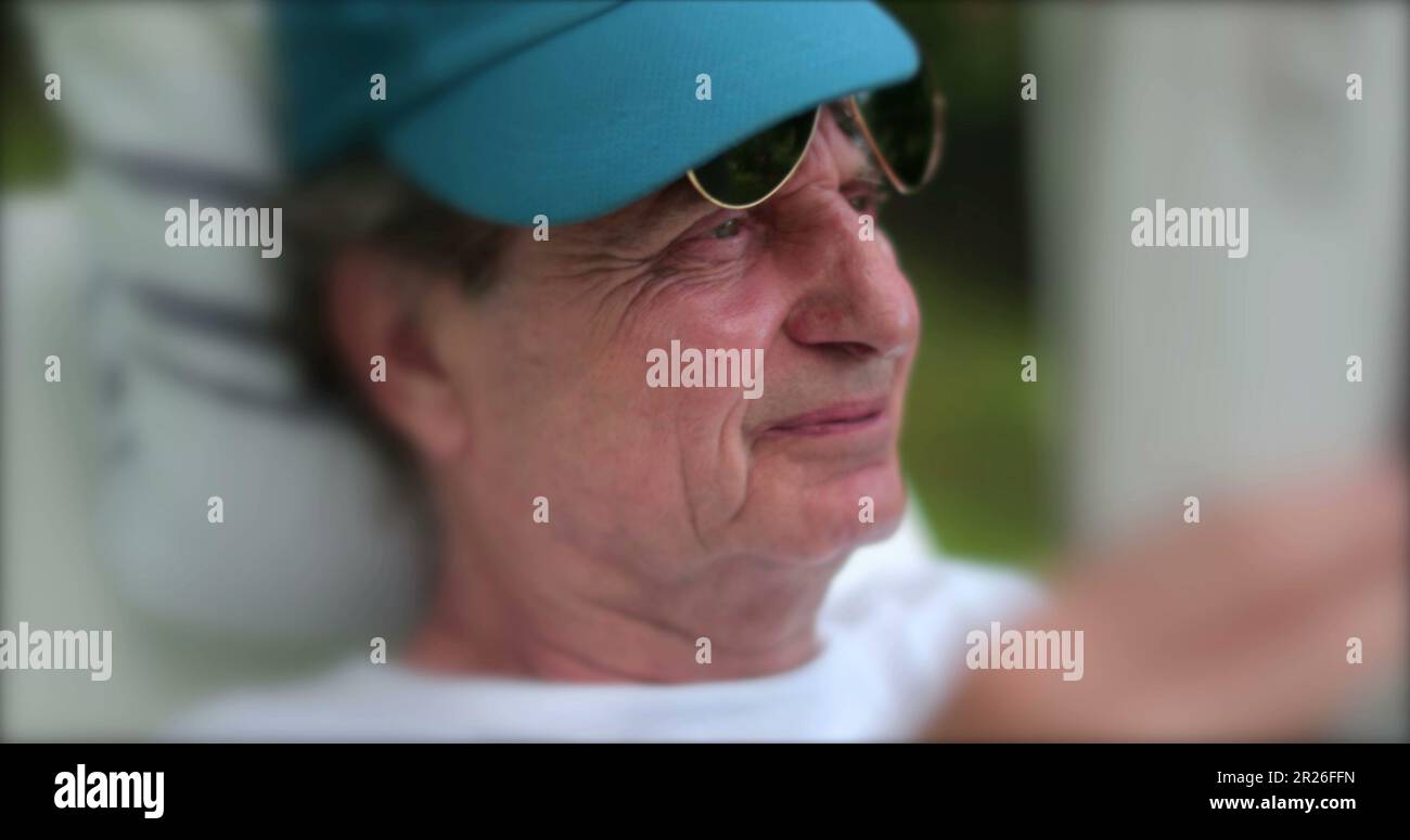 Casual closeup older man reading newspaper outside Stock Photo - Alamy