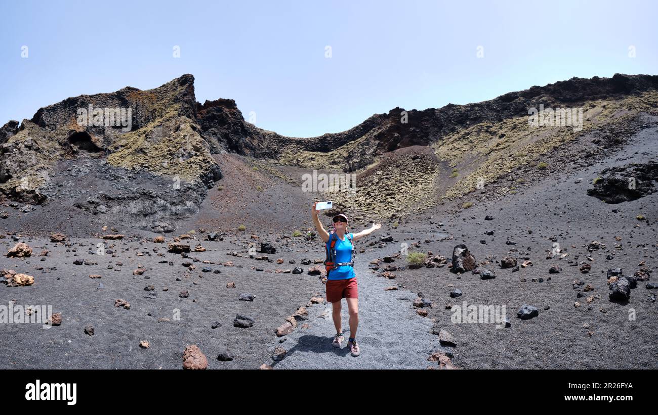 Woman taking selfie mobile phone standing volcano el cuervo hi-res ...