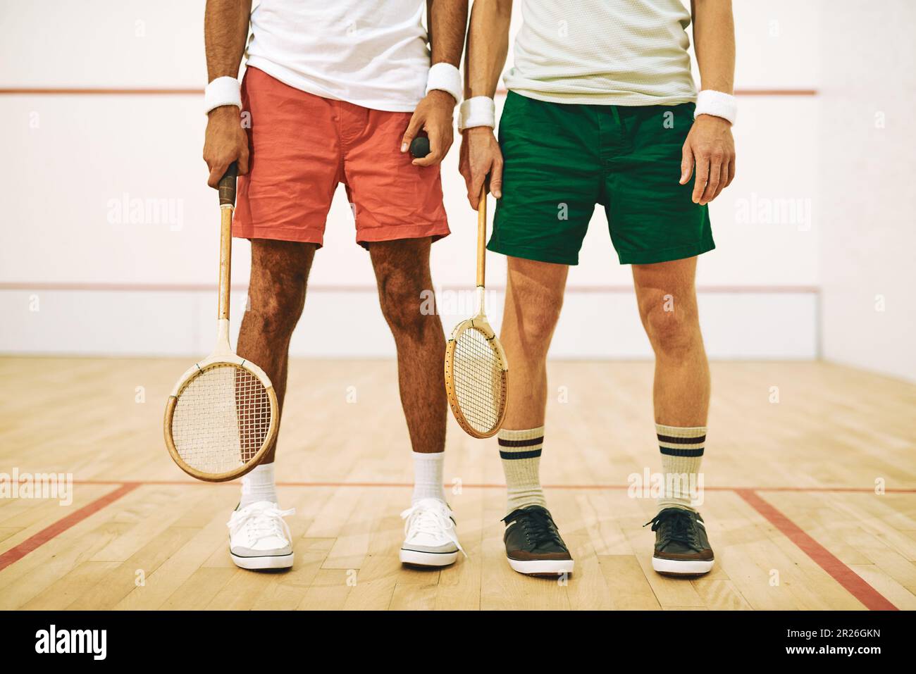 To play squash youve got to dress the part. two men holding their ...