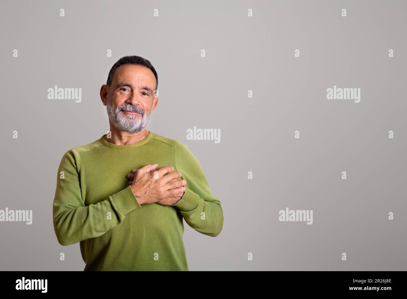 Cheerful confident attractive old european man puts his hands to chest ...