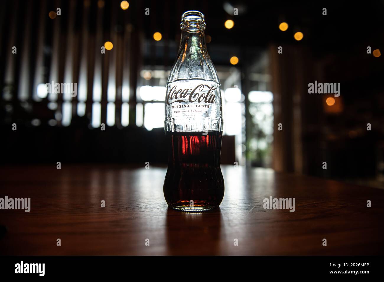 Coca Cola bottle on the table of a modern bar, lit from behind Stock ...