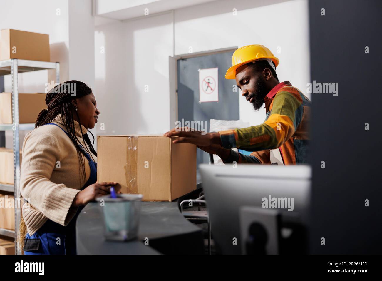 Warehouse reception worker inspecting received cardboard box packing ...