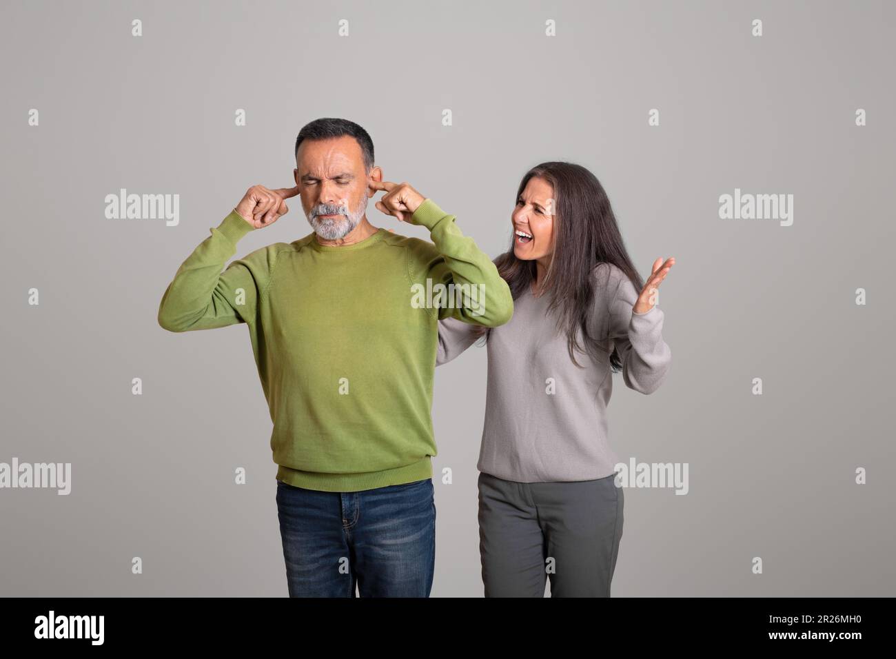 Sad angry european old wife yells at husband, man covers ears with ...