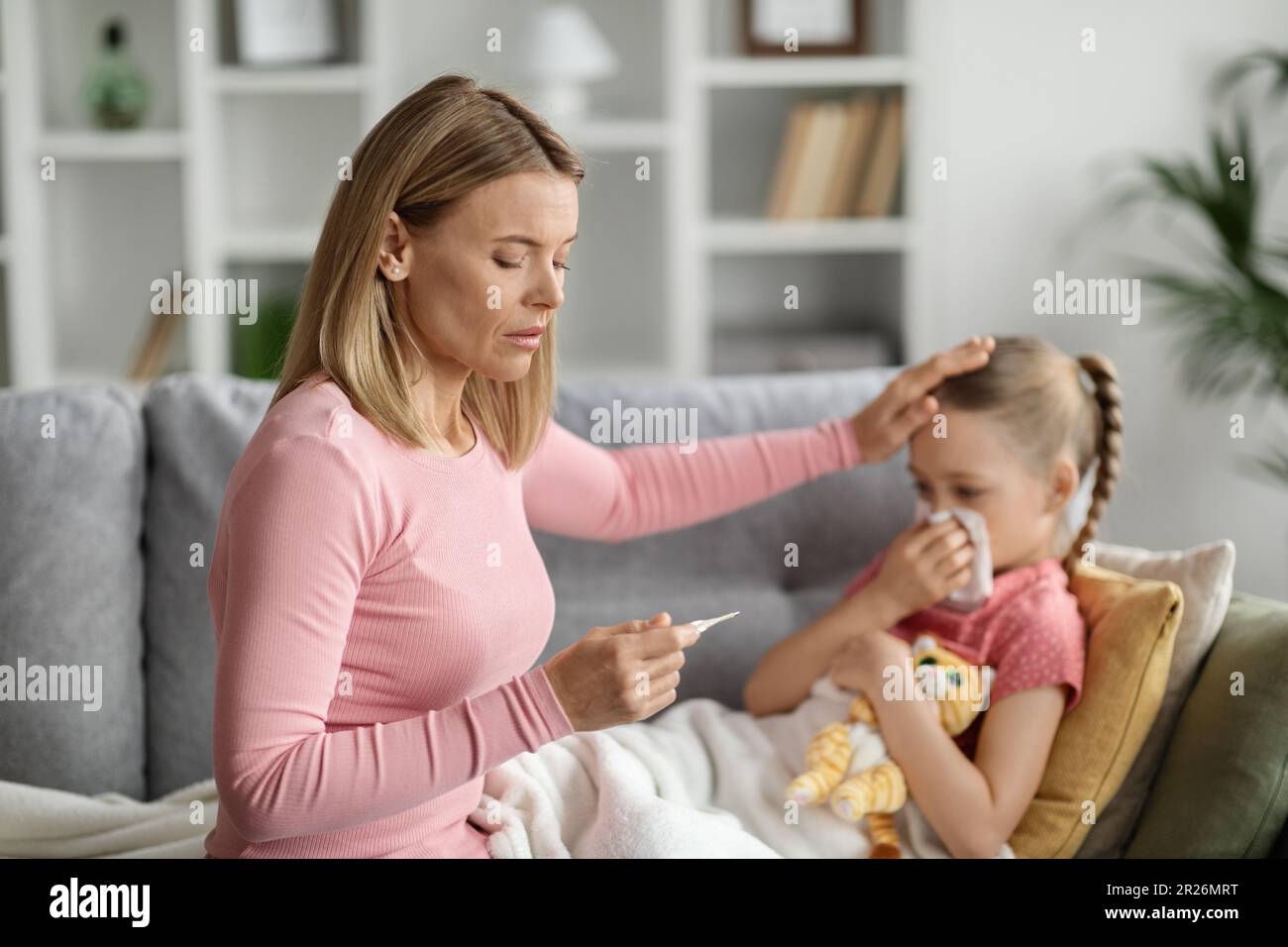 Seasonal Flu Concept. Worried Mother Taking Care Of Ill Daughter At ...