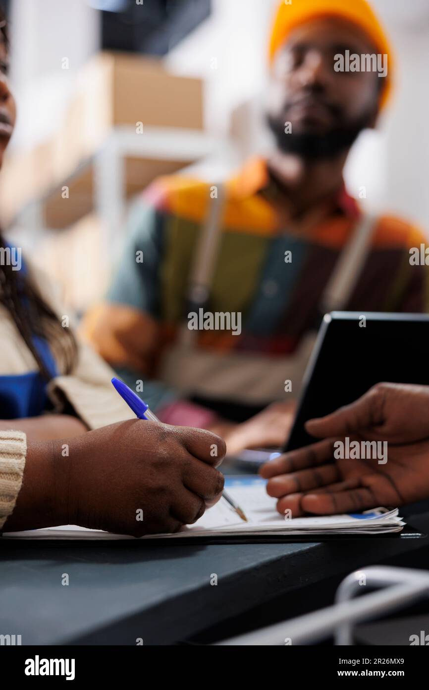 Warehouse worker hand writing in clipboard at reception desk Stock ...