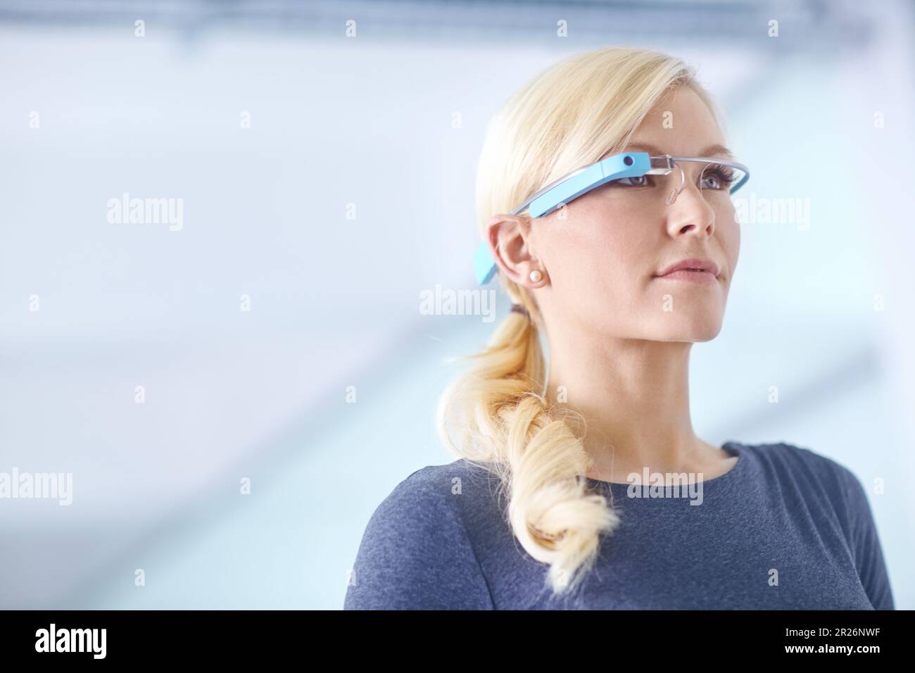 Future tech now. a young woman standing in an office wearing smart ...