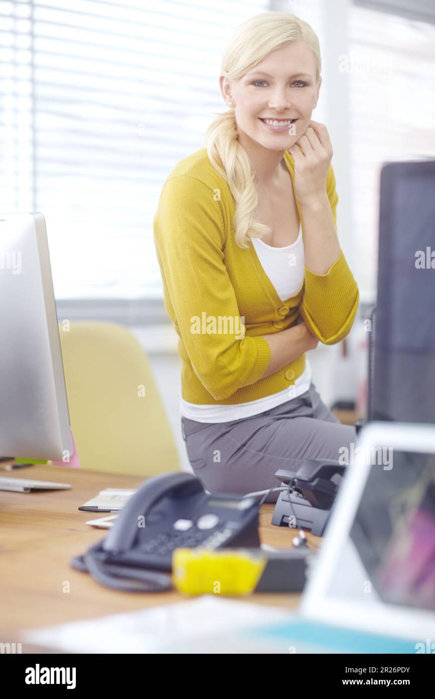 Portrait beautiful business woman sitting on her desk in the office and ...