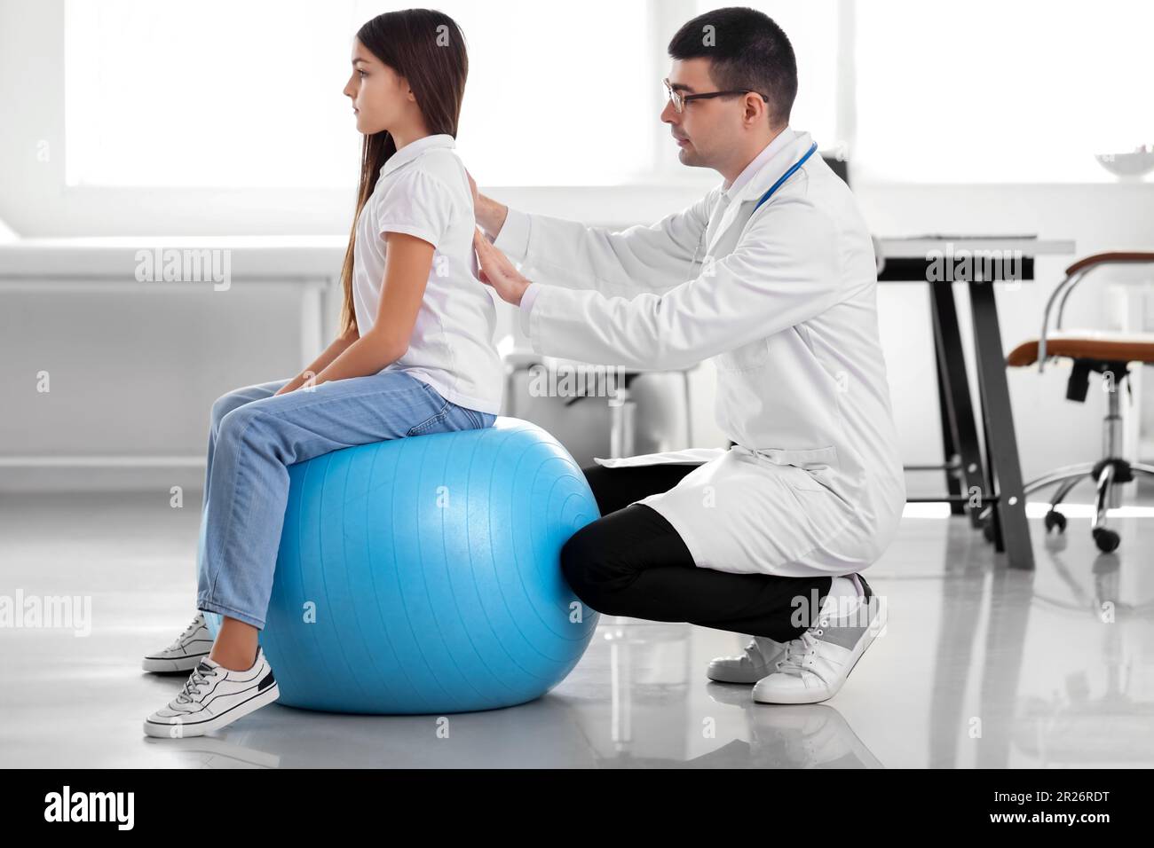 Doctor checking posture of little girl in clinic Stock Photo - Alamy