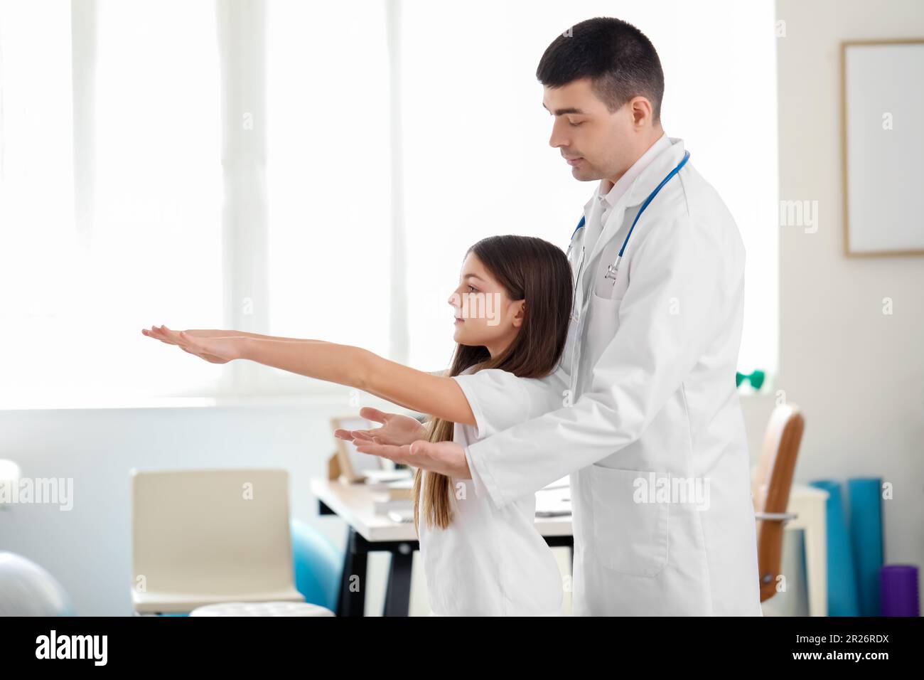 Doctor checking posture of little girl in clinic Stock Photo - Alamy