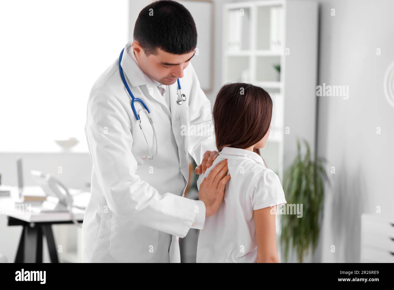 Doctor checking posture of little girl in clinic Stock Photo - Alamy
