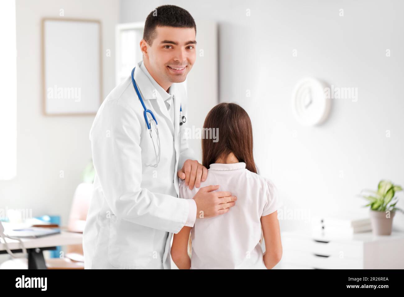 Doctor checking posture of little girl in clinic Stock Photo - Alamy