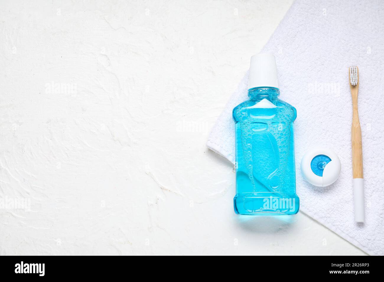 Dental floss, toothbrush and mouthwash on white towel Stock Photo - Alamy