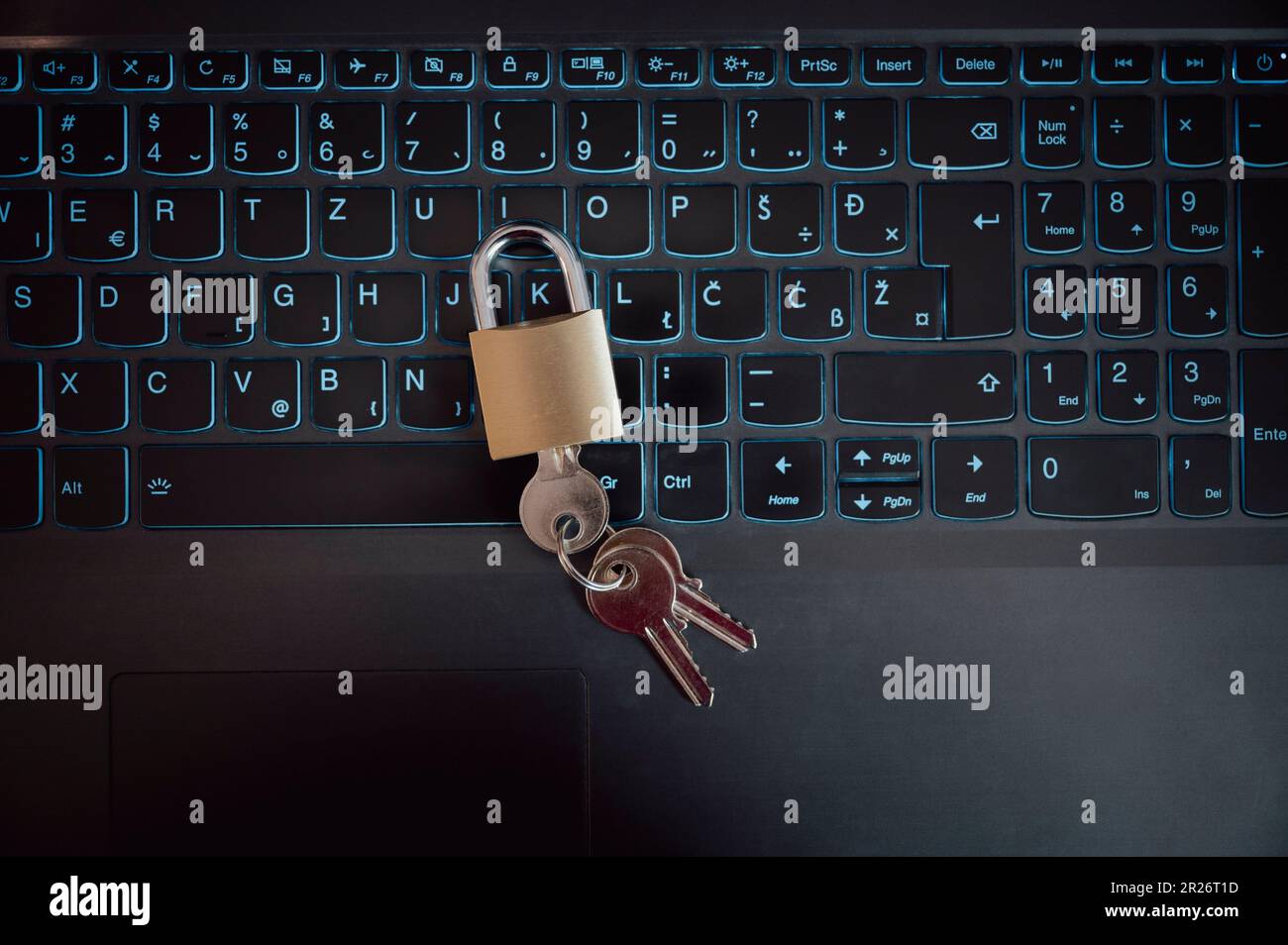 Top view of a golden padlock with keys in it placed on laptop computer ...