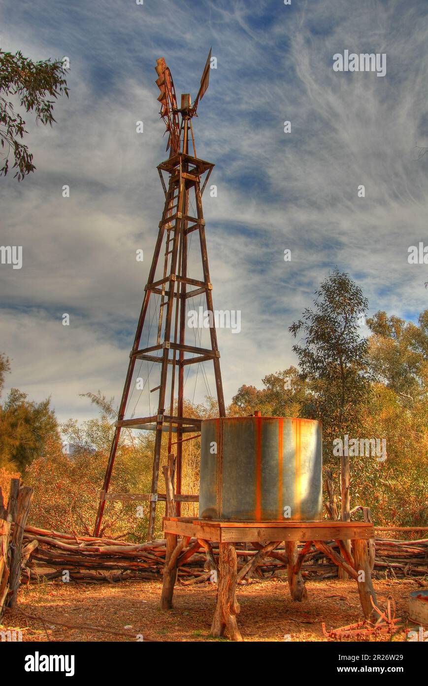 Windmill and water storage tank by a desert corral Stock Photo - Alamy
